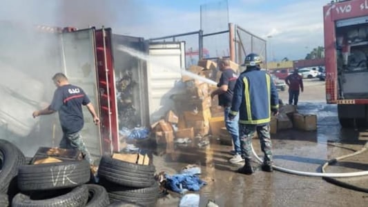 Photo: Members of the Beirut Fire Brigade work to extinguish a fire in ...